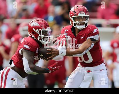 Arkansas running back Mike Washington (4) goes airborne as he's tripped ...