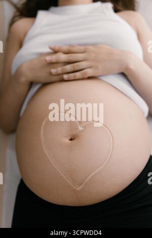 Doctor applies ultrasound gel in smiley shape on pregnant belly before ...