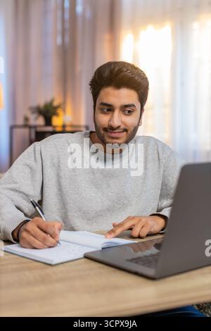 Teacher taking online lecture through video call on laptop at desk ...