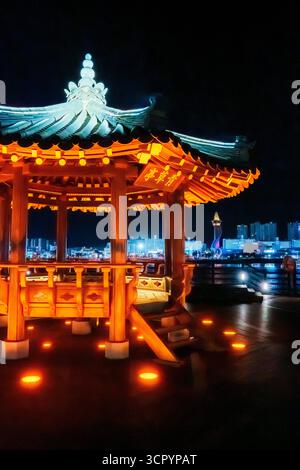 Traditional lakeside pavilion glowing at night with modern Sokcho ...