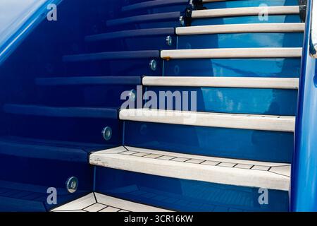 Teak wood stairs descending between decks of a modern luxury yacht ...