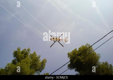 helicopter flying overhead in blue sky Stock Photo - Alamy