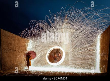 View of a spinning fire steel wool glowing in the darkness Stock Photo ...