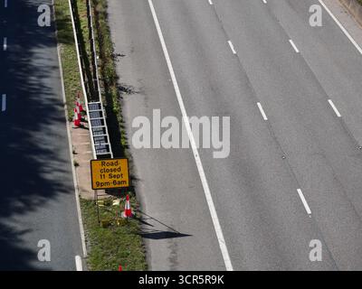 Road closure advance warning sign on the side of carriageway, overhead ...