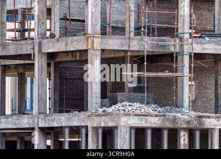 A construction site with large concrete pillars and power lines under a ...