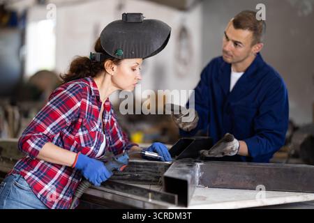 Man trains woman to do connecting iron rails with welding machine Stock ...