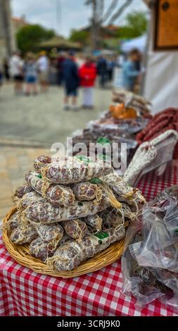 Pile of tasty salami sausages piled on a street market stall in France ...