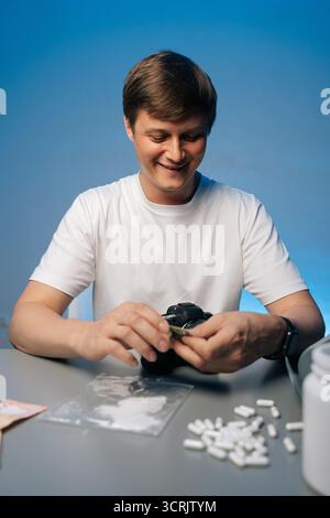 Vertical portrait of drug dealer sitting at desk with scattered cash ...