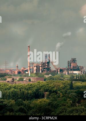 Industrial landscape with smokestacks emitting smoke over a coastal ...