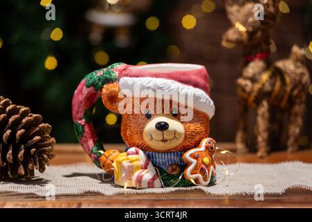 A cute gingerbread-man mug sits beside a red Merry Christmas gift box ...