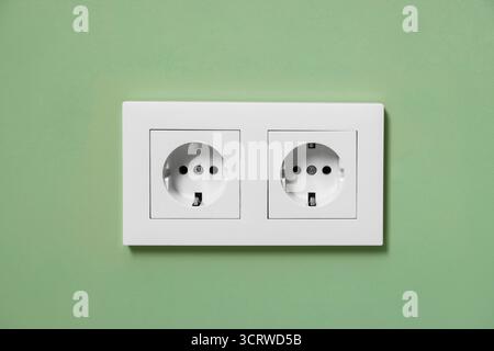 Electric power sockets on green wall, closeup. Space for text Stock ...