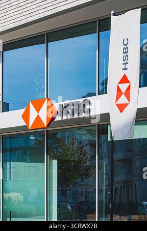 Facade of HSBC bank branch with red and white logo on concrete office ...