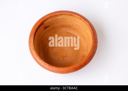 empty rustic terracotta kitchen bowl and spoon on a wooden tabletop ...