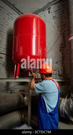 Technician inspecting heating system in boiler room Stock Photo - Alamy