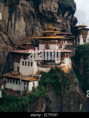 Historic temple building perched on a rocky cliff overlooking lush ...