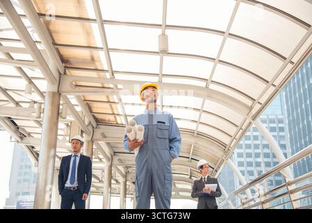 Civil engineer teams meeting working together wear worker helmets hardhat on construction site ...