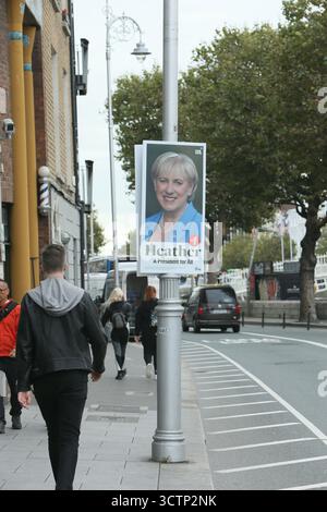 People walk past a campaign poster of President Alassane Ouattara in ...