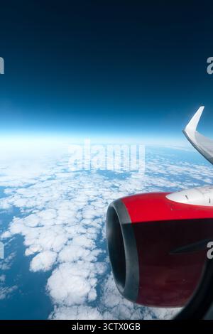 A closeup view of an airplane wing over the fluffy clouds Stock Photo ...