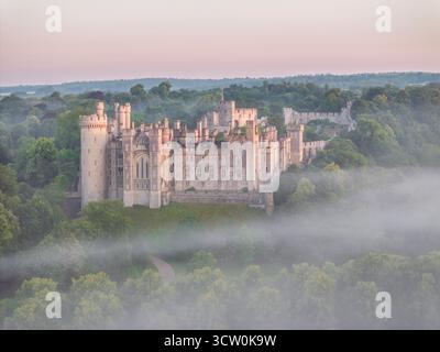 Aerial view of Arundel Castle at dawn on a misty summer morning ...