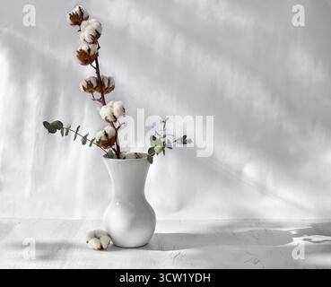 Vase with eucalyptus branches on table near couch in living room Stock ...
