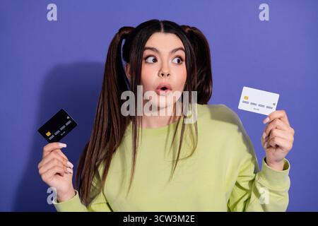 Surprised young woman with credit cards and shopping bags on red ...