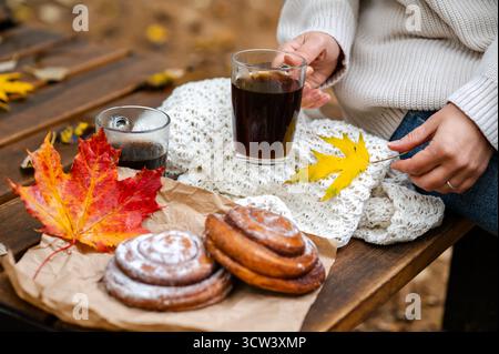 Woman's hands in a knitted sweater writing on a large red paper heart ...