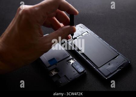 Process of mobile phone repair. Hands of a service worker repairing ...