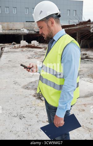 Construction supervisor wearing safety helmet and reflective vest ...