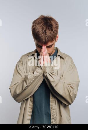 A man bows his head in prayer after a noon service by the Archbishop of ...