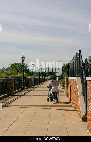 A woman pushes a baby stroller while walking around in a commercial ...