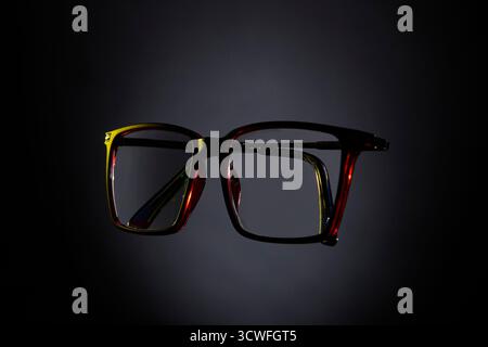 A closeup of rectangular optical glasses on a flat surface with a neon ...