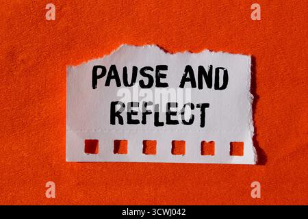 Pause and reflect message written on ripped torn yellow paper with blue ...