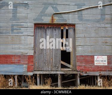 A wooden door shows signs of decay as it stands in an ancient stone ...