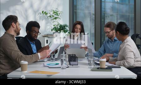 Team of business men and women showing and pointing up with finger number one while smiling ...