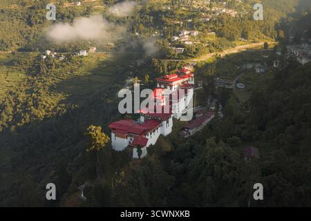 Aerial view of Trongsa Dzong perched atop a mountain ridge, its white ...
