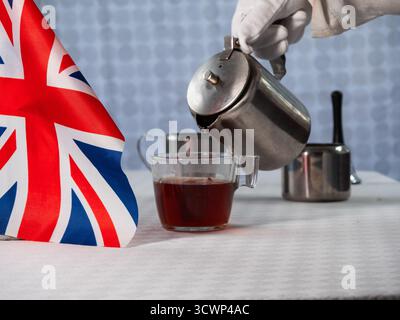 Waiter pouring traditional English tea from teapot Stock Photo - Alamy