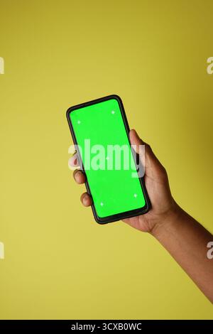 Modern smartphone with a bright green screen placed on a wireless ...