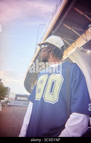 Man standing relaxed under bridge on the beach Stock Photo - Alamy