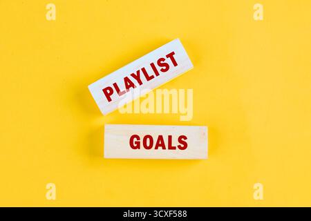 Two wooden blocks with the words playlist and goals are set against a ...