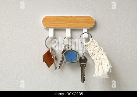 Rack with keys hanging on grey wall, closeup Stock Photo - Alamy