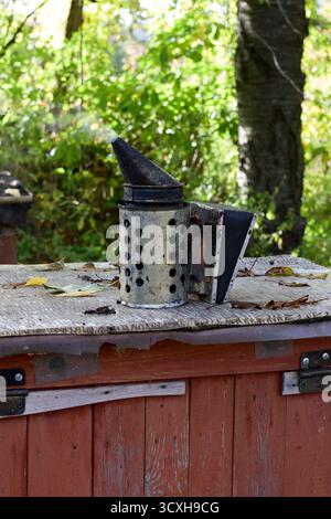 rustic smoker that is used in beekeeping to scare away the bees when ...