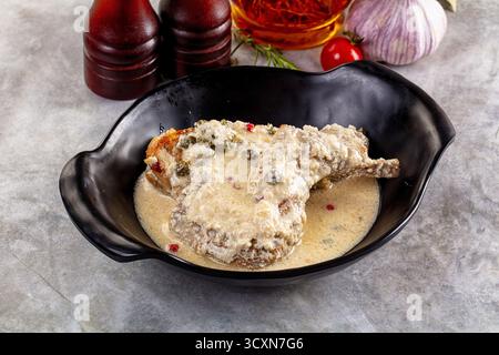 Roasted rabbit legs in cream sauce with capers Stock Photo - Alamy