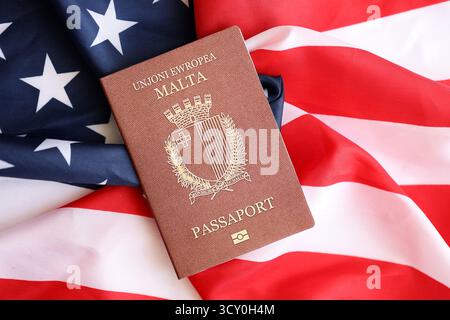 Malta passport on big waving flag of United States of America close up ...