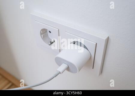 USB charging cord inserted into a wall power socket Stock Photo - Alamy