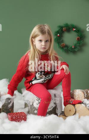 A blonde girl with a Christmas gift in her hands, on the background of ...