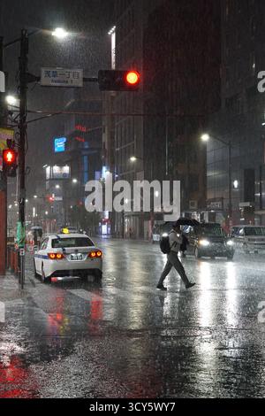 Rain-soaked pavement with people walking by at dusk Stock Photo - Alamy