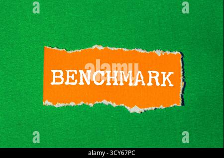 Benchmark message written on ripped torn paper background. Conceptual ...