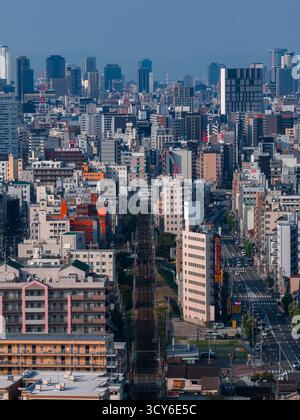 Aerial view of Osaka rail corridor cutting through dense urban blocks ...