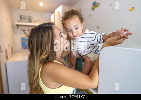 Smiling mother holding children's hands in back yard Stock Photo - Alamy