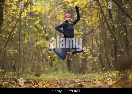 Woman running among autumn leaves Stock Photo - Alamy